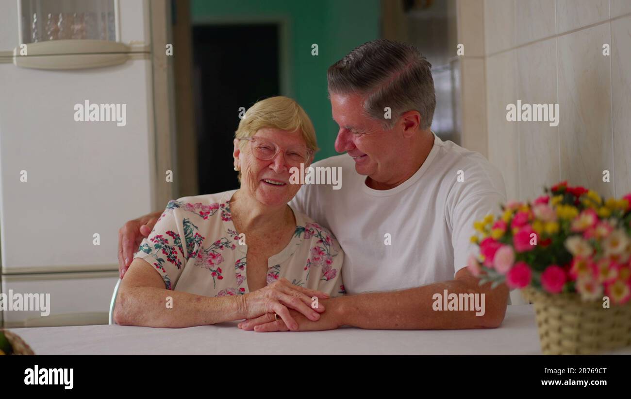 Joyful middle-aged son with his elderly mother interaction while ...