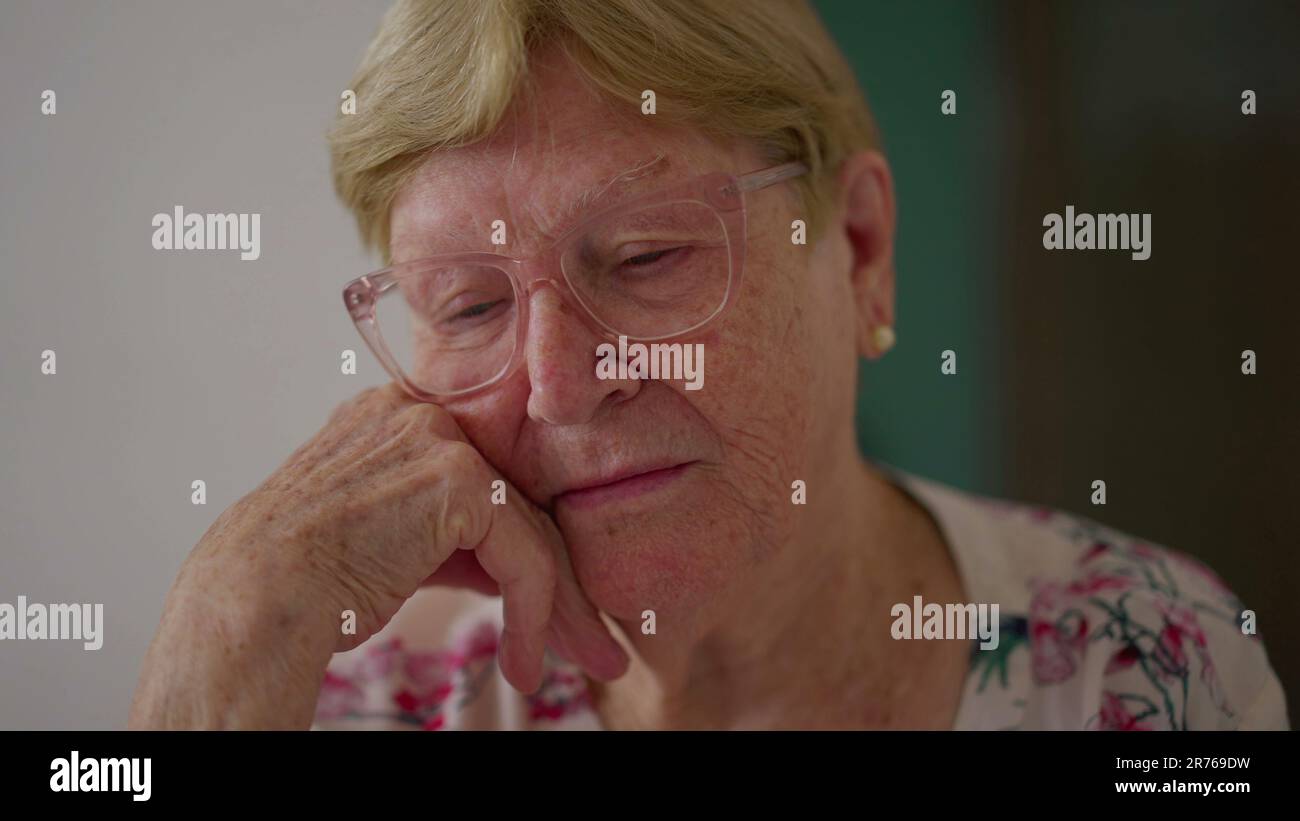 Contemplative senior woman reminiscing past memories. Elderly person in ...