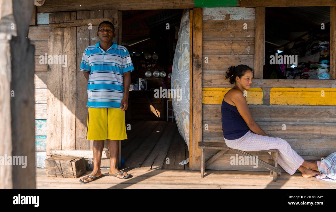 Indigenous man and woman outside their wooden house Stock Photo - Alamy