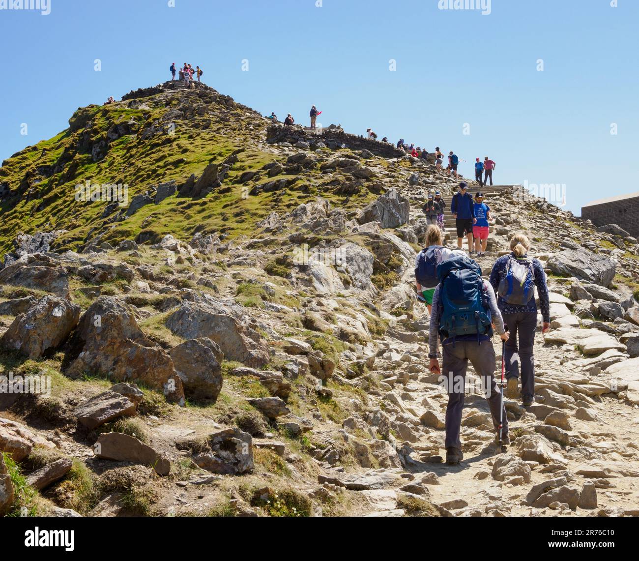 Walkers making the final ascent to the summit cone of Snowdon Yr ...
