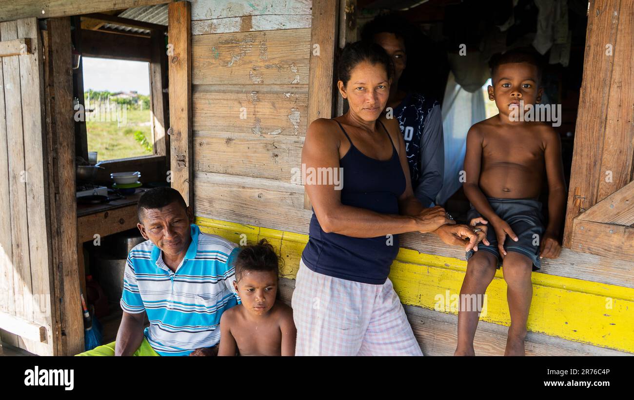 Entire indigenous family in front of their wooden house in the ...