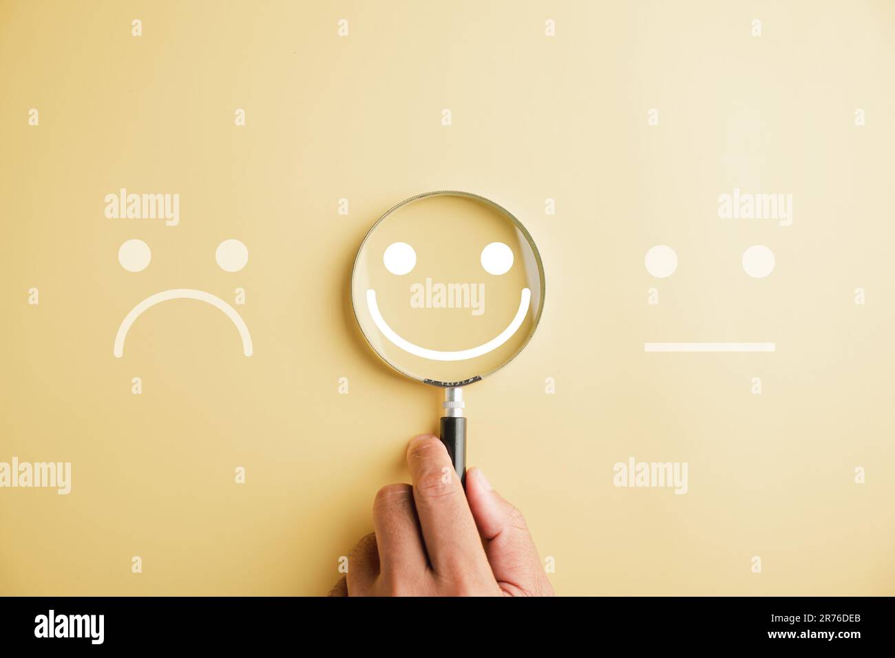 Magnifier in hand focuses on selected happy smiley face icon Stock ...