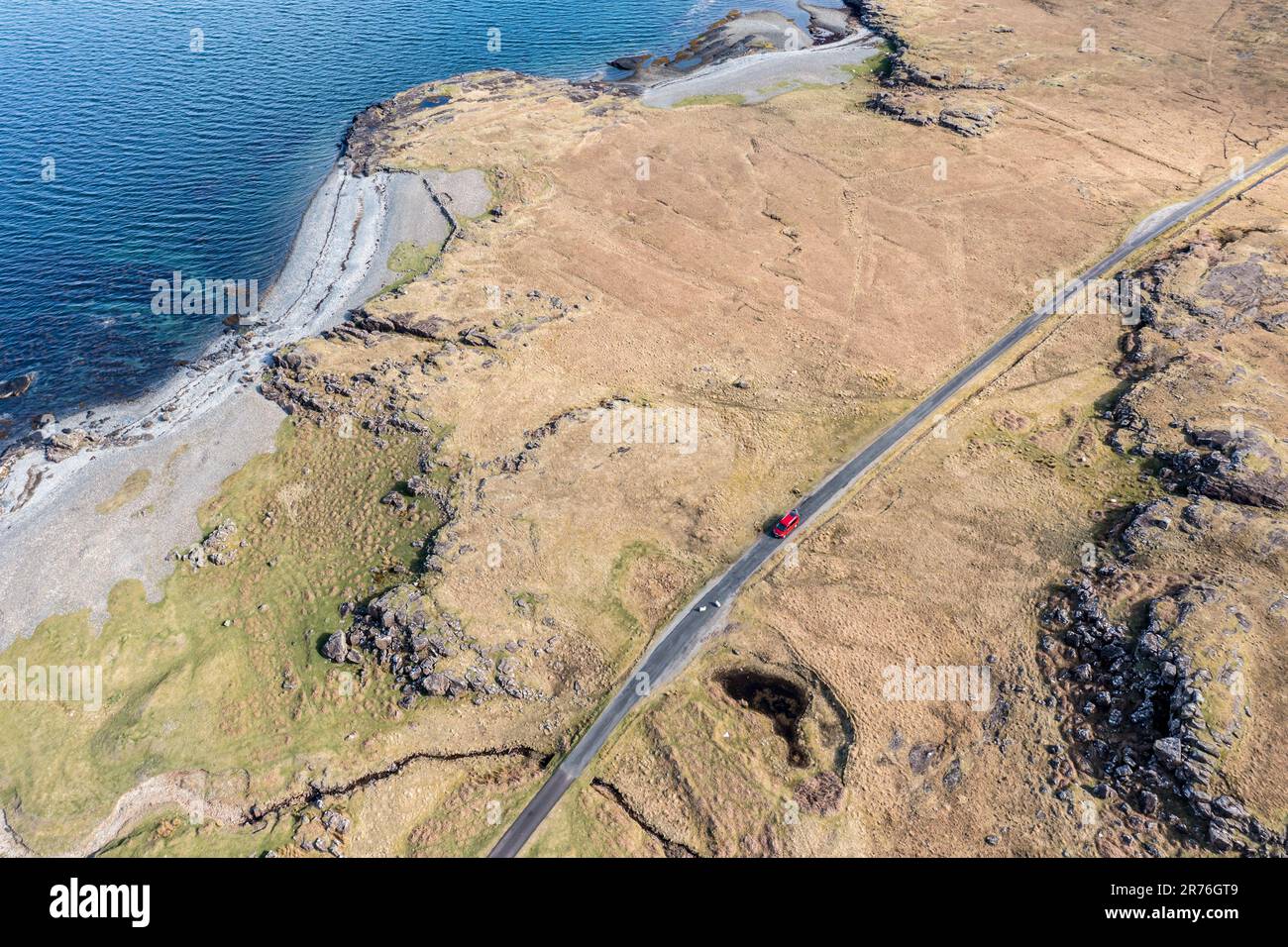 Aerial view over coast at Loch na Keal, coastal road, sheep and red car ...
