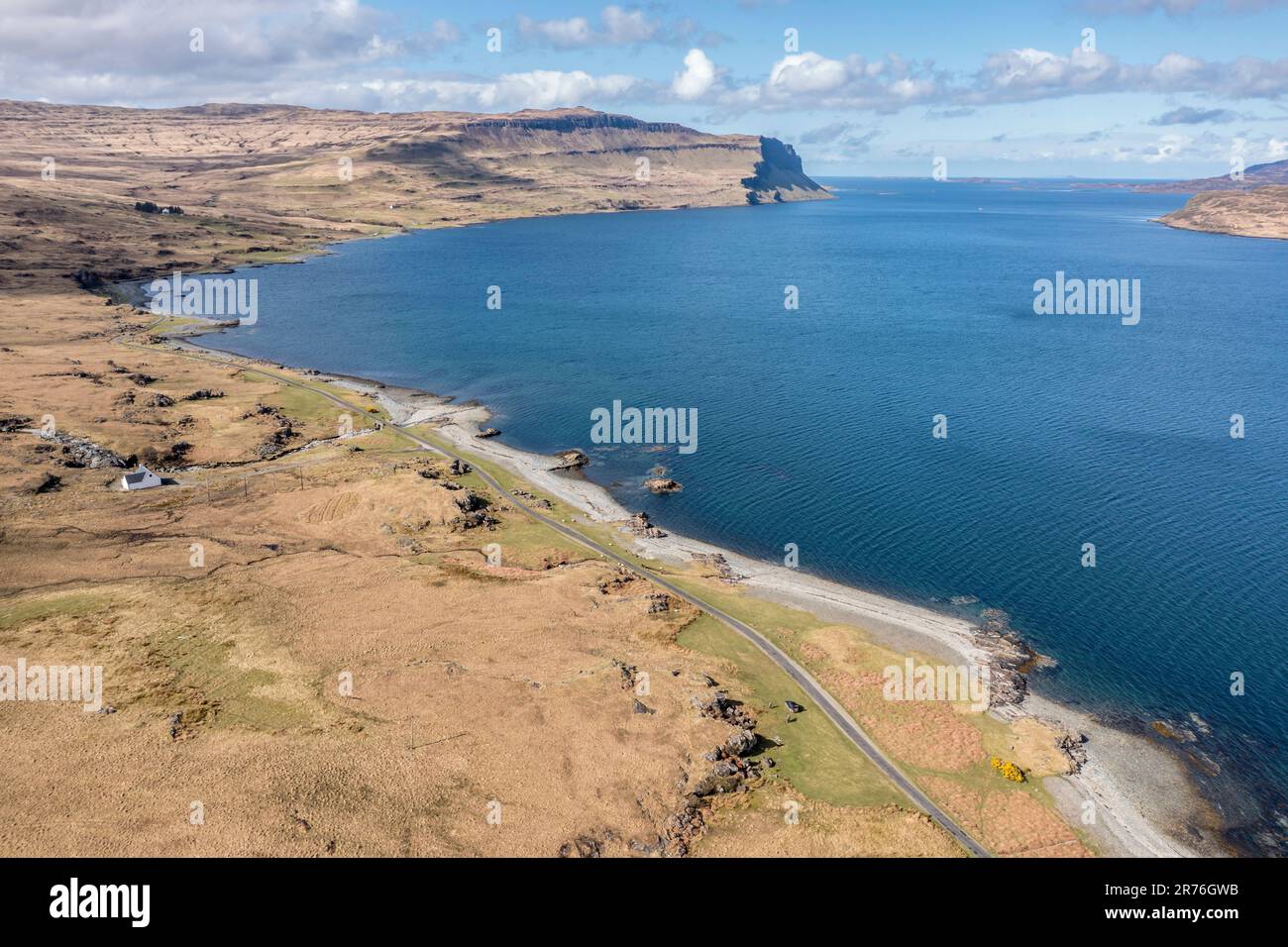 Aerial view over coast at Loch na Keal, coastal road and lonely house ...