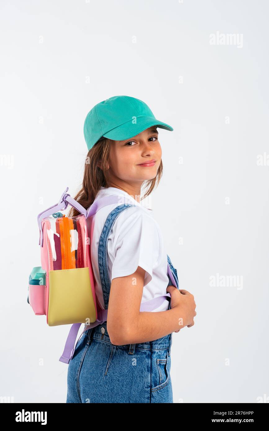 Side view of cute little girl in casual clothes and green hat with ...