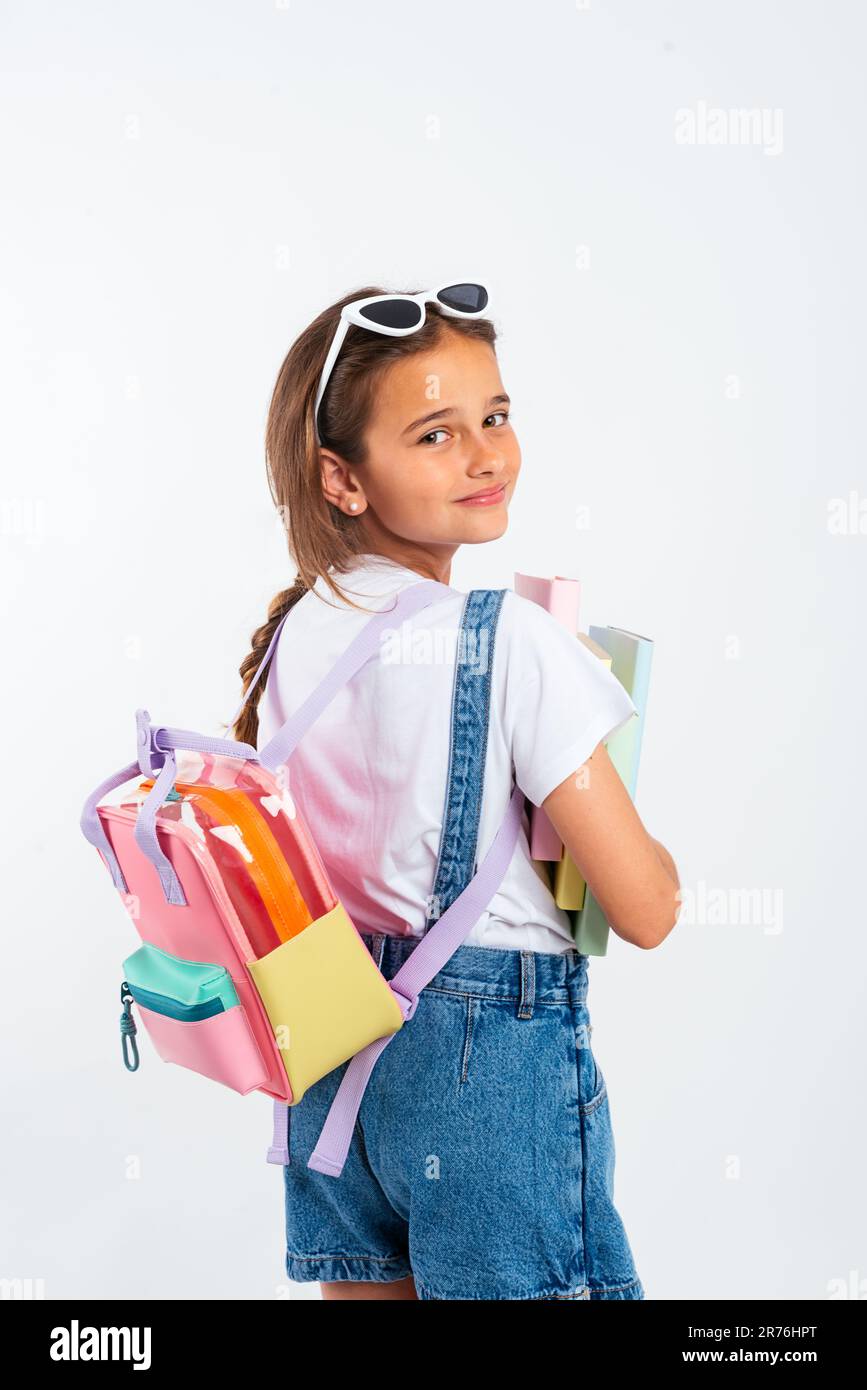 Side view of cute little girl in denim overall and sunglasses standing ...