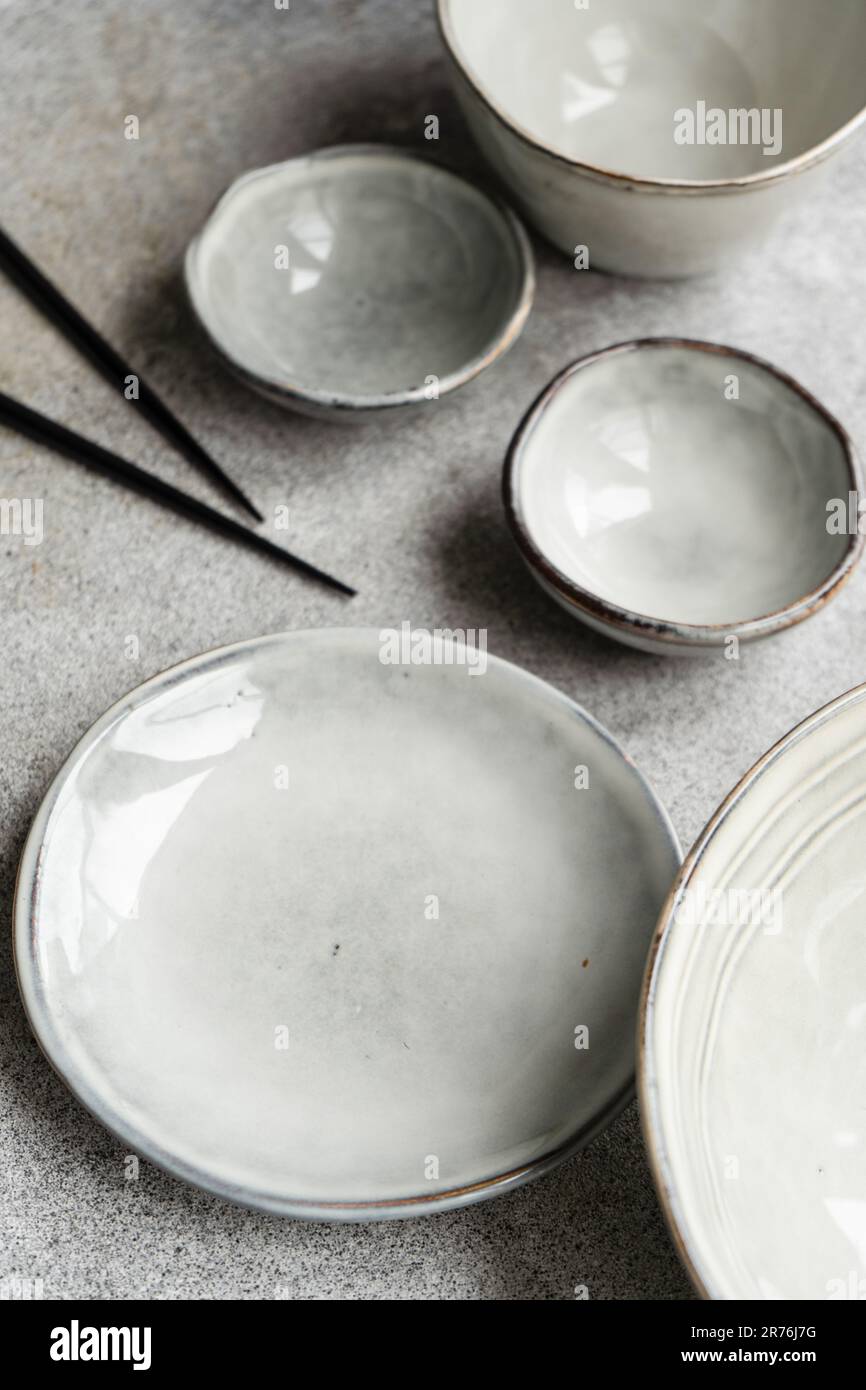 Set of grey ceramic crockery on a concrete background in the same color ...