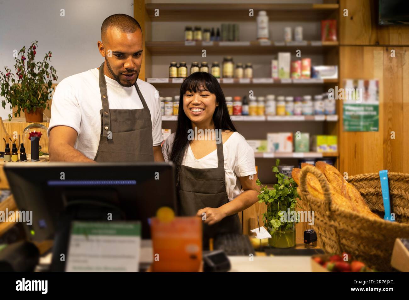 Positive young multiracial coworkers in aprons positive and using ...