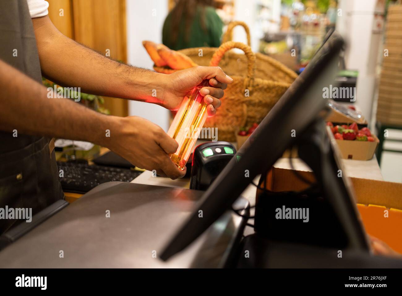 Unrecognizable male seller using scanner to sell bottle of oil for ...