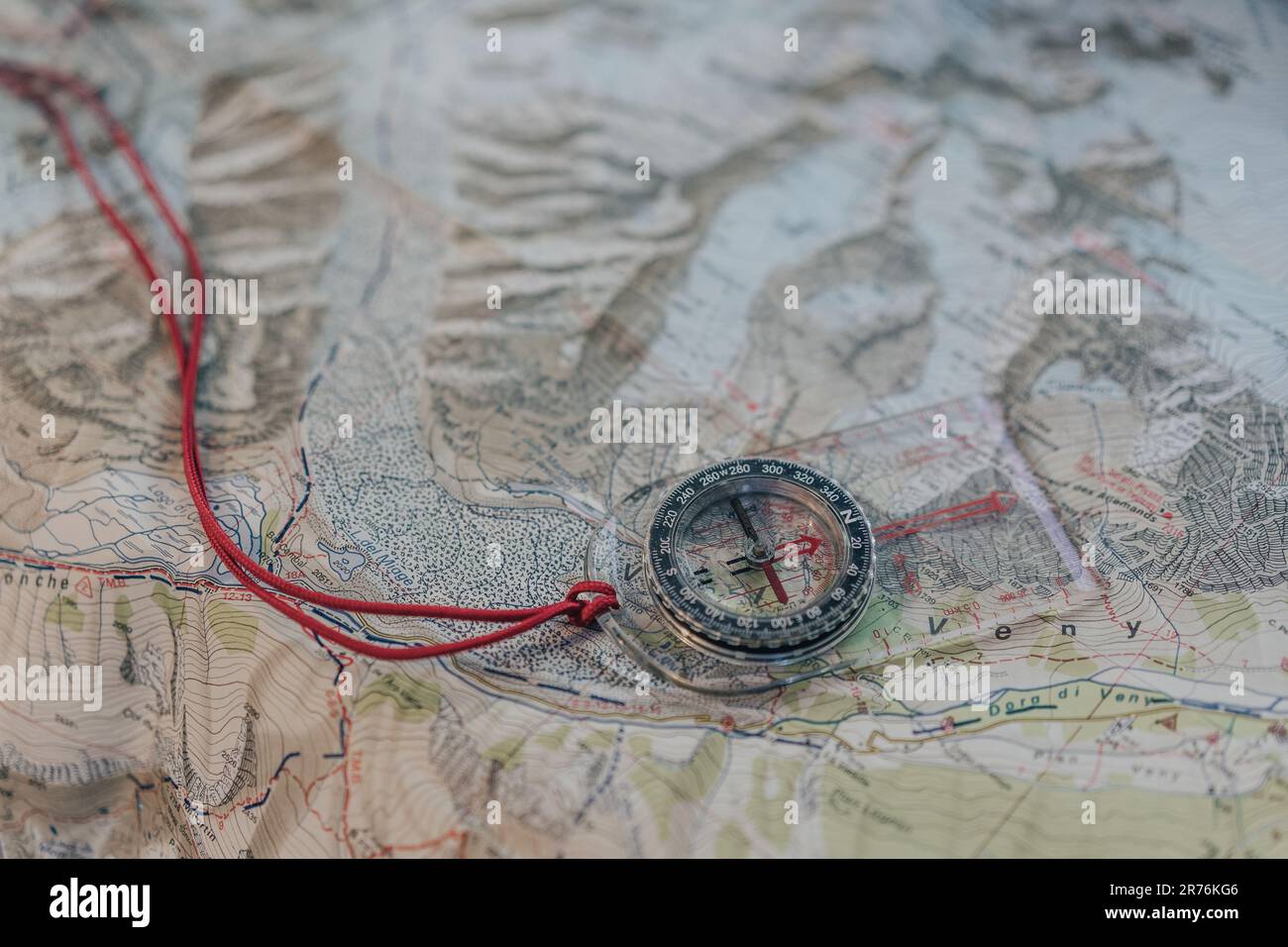 Close up detail of a compass on top of a topographic map. Planning an ...