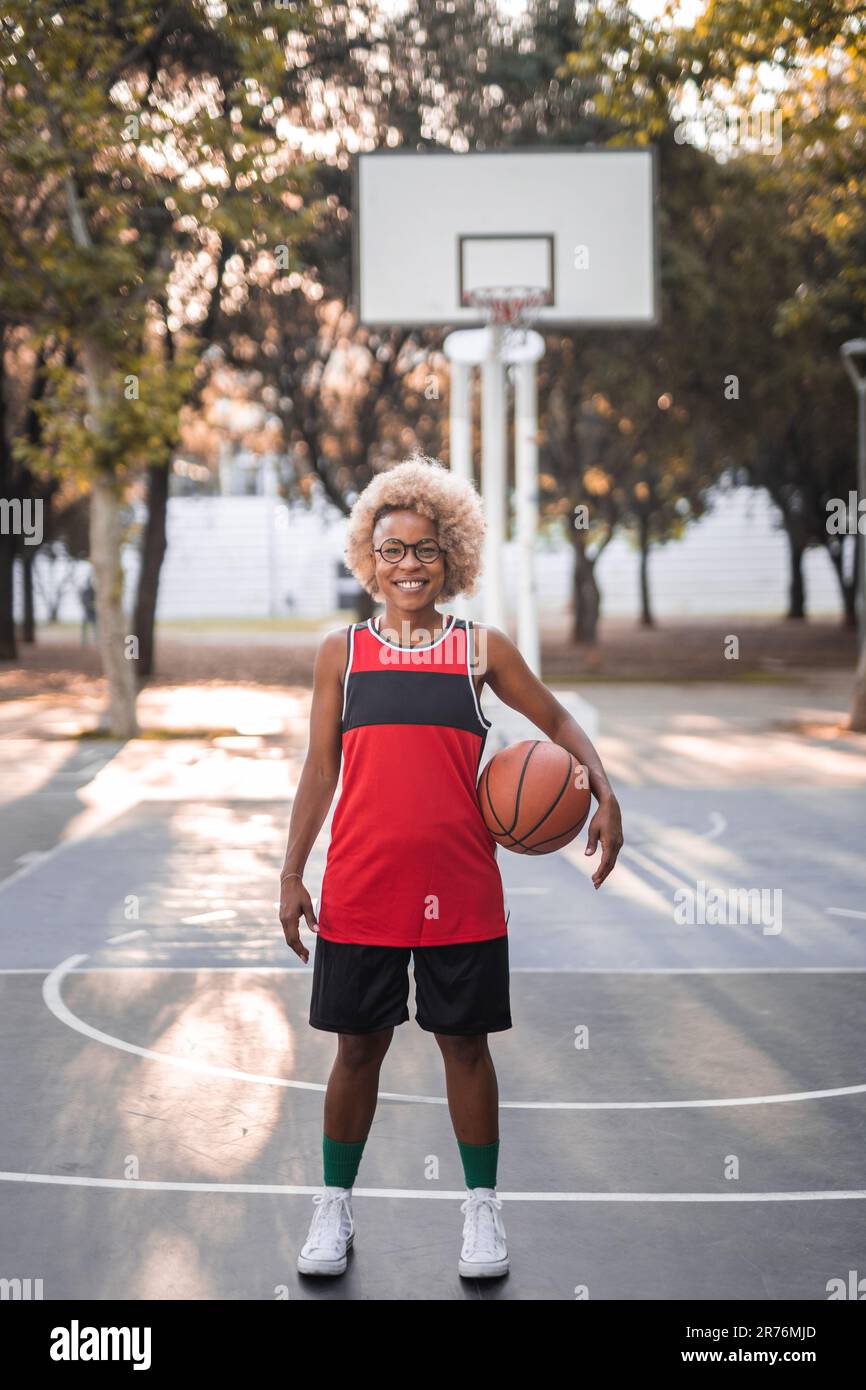 Full body of young African American female basketball player in ...