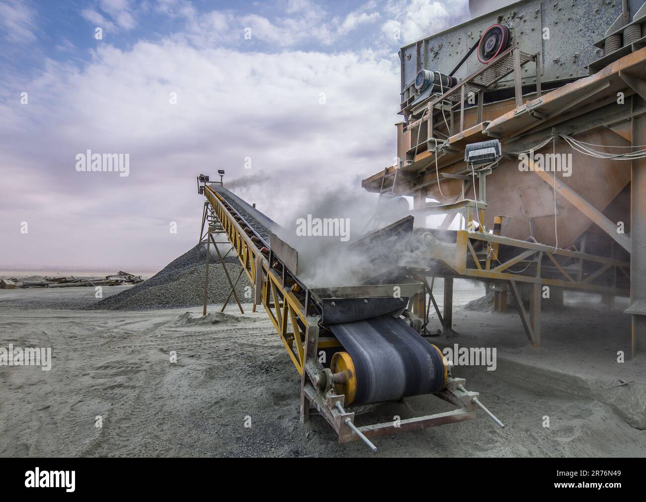 Conveyor belt of heavy machinery loading stones during work process in ...