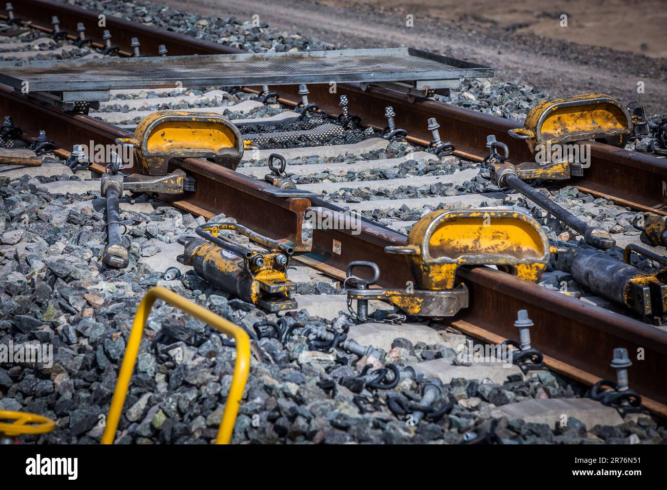 High angle of metal construction with railway lines held by clamps over ...