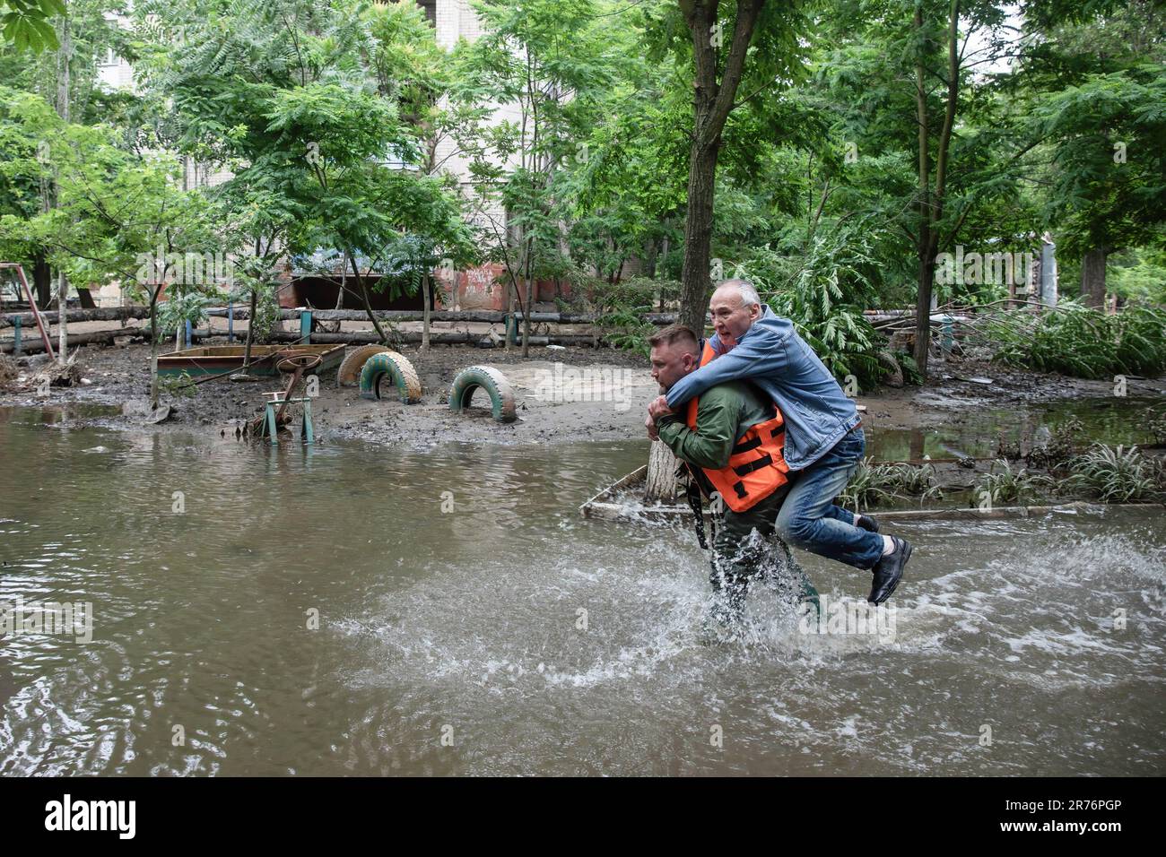 Rescue worker shoulders a man out of a flooded area. The explosion of ...