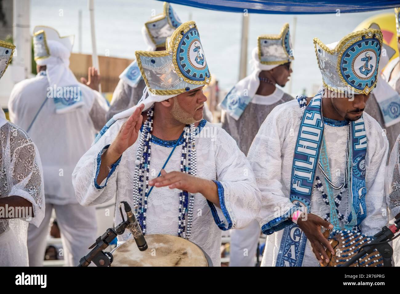 A group of five men in traditional cultural clothing playing various ...