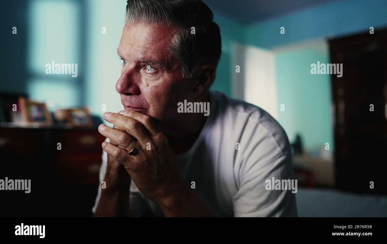 Depressed middle age man suffering alone in home bedroom while lifts up ...