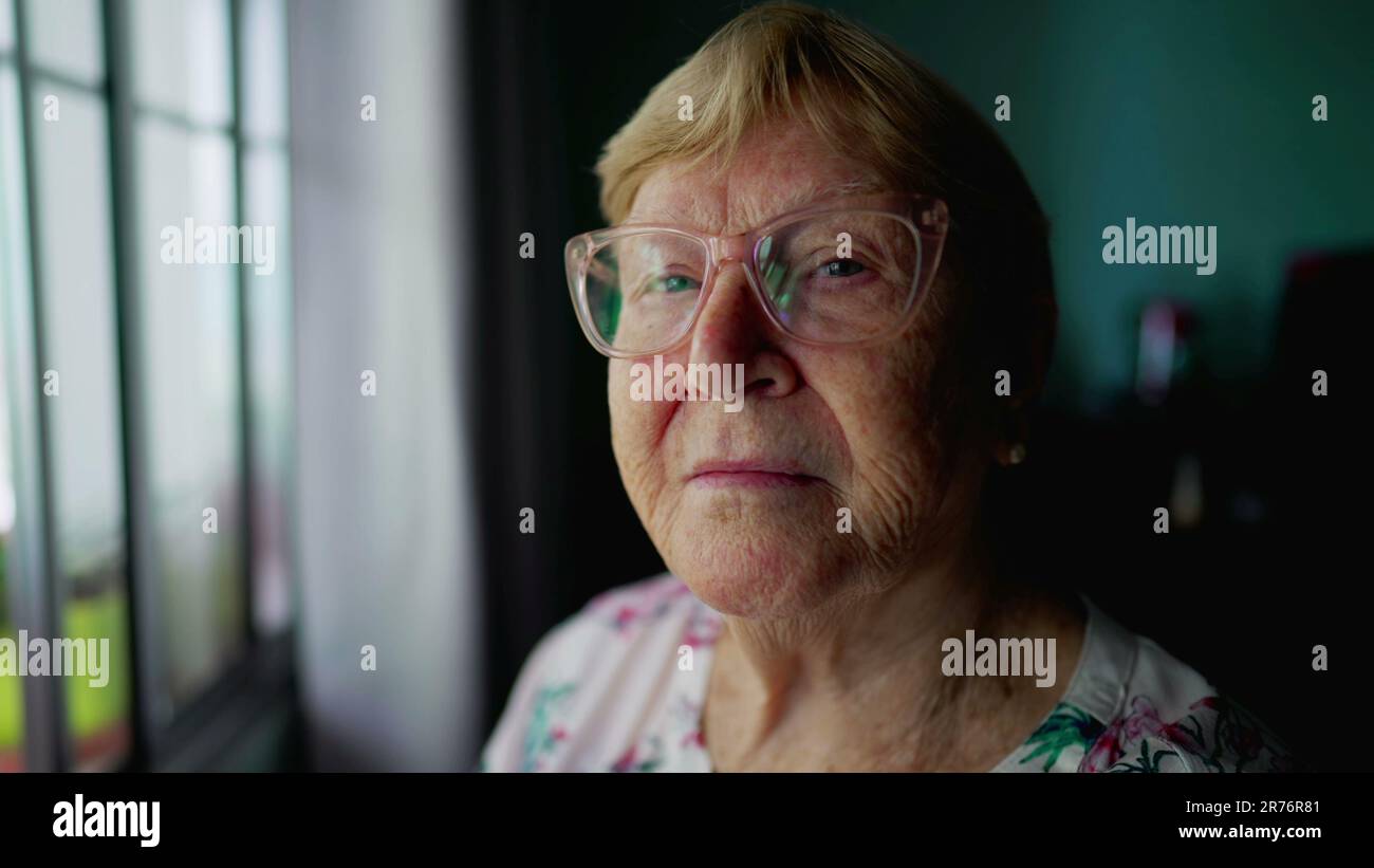 Portrait of Elderly Woman Looking at Camera by Home Window, Depicting ...