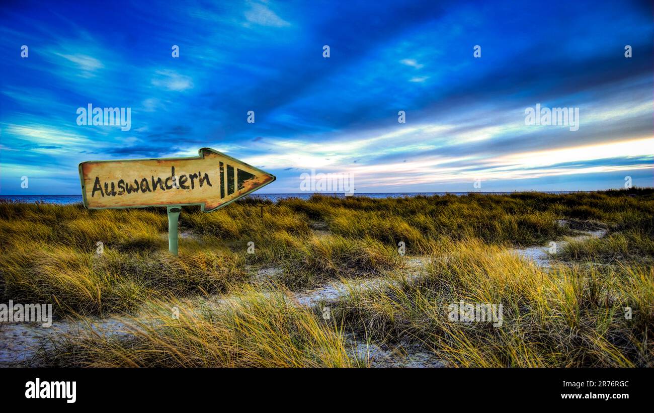 Image shows a signpost and a sign in the direction of emigration and ...