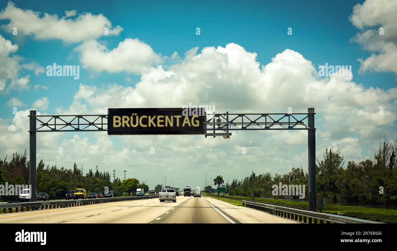 picture shows a signpost and a sign pointing to bridge day in german ...