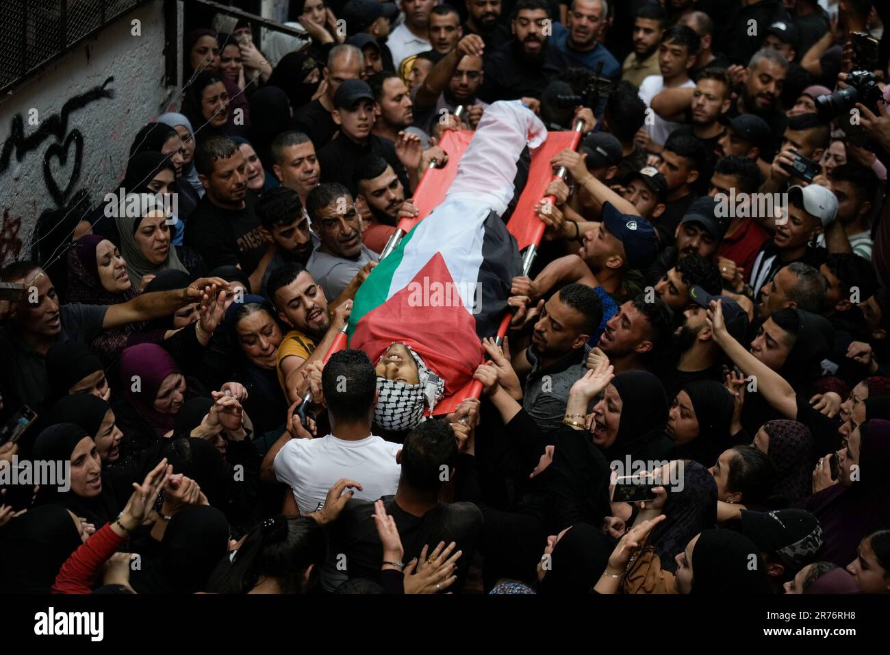 Palestinians carry the body of 19-year-old Faris al-Hashash during his ...
