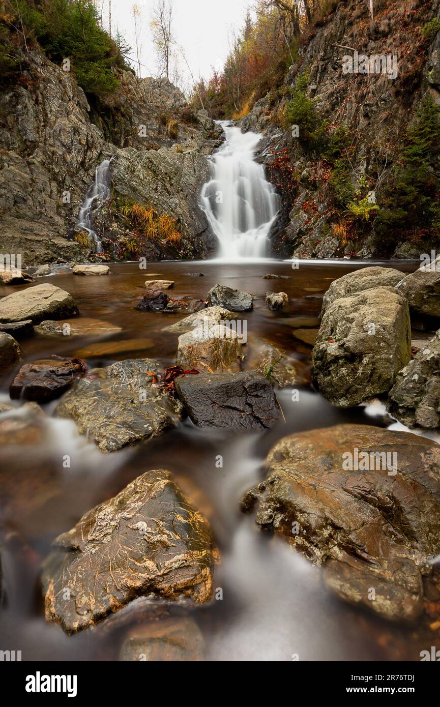A stunningly beautiful waterfall cascading over rocks, with lush trees ...