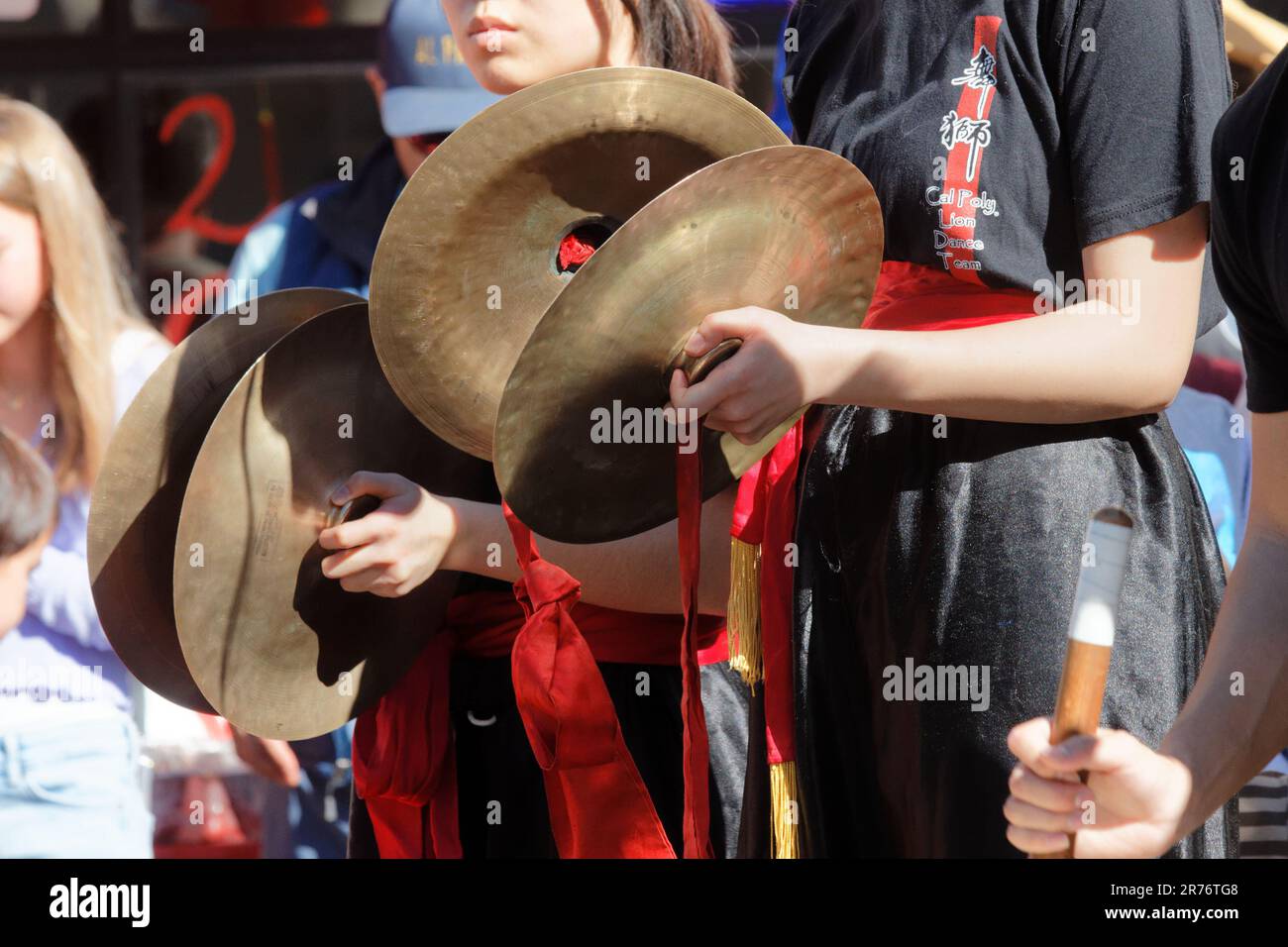 Three young female musicians stand in a crowd, proudly holding their ...