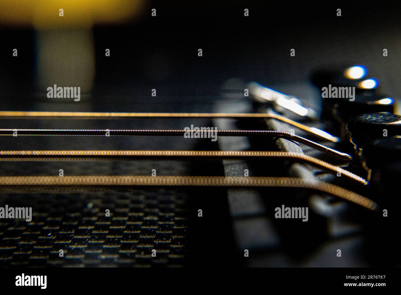 A detailed close-up of an electric guitar fretboard with a yellow light ...