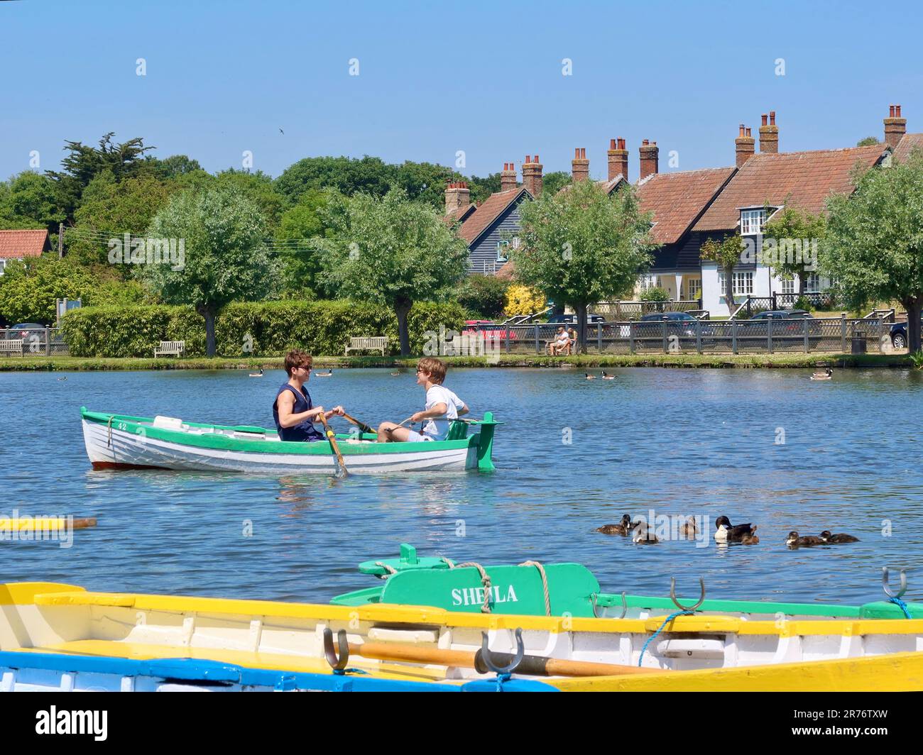 Thorpeness, Suffolk, UK - 13 June 2023 : Two boys rowing a boat on the ...