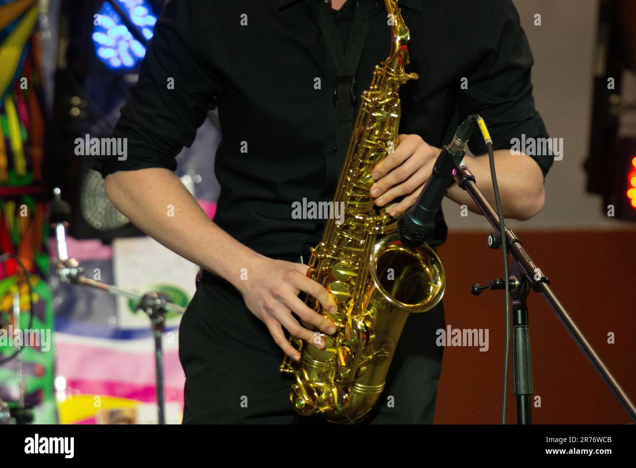 A young adult male wearing a black shirt and trousers playing a ...