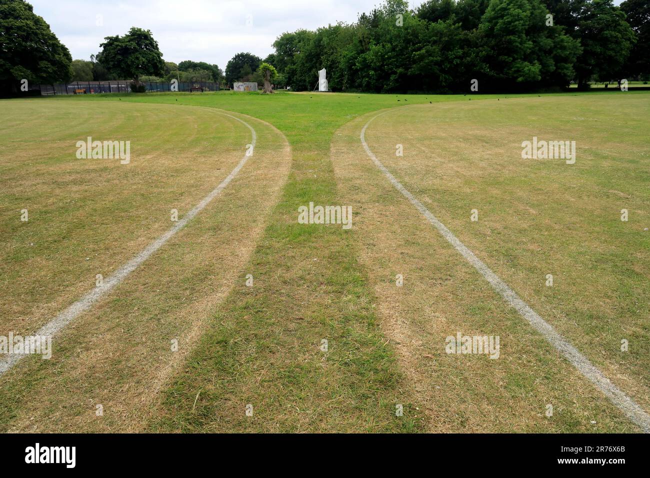Converging boundary lines between two cricket pitches making an ...