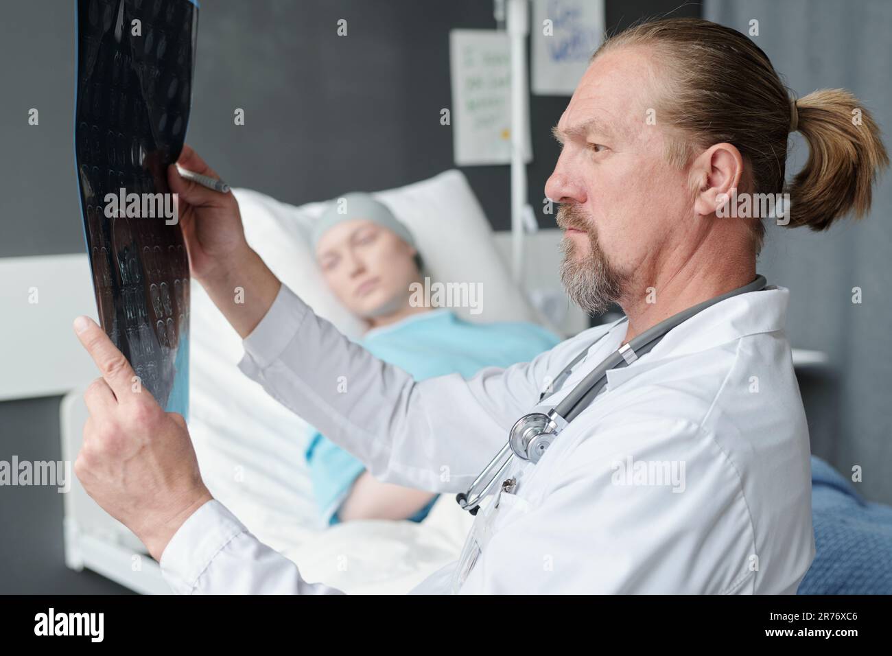 Side view of mature serious oncologist or radiologist looking at MRI ...