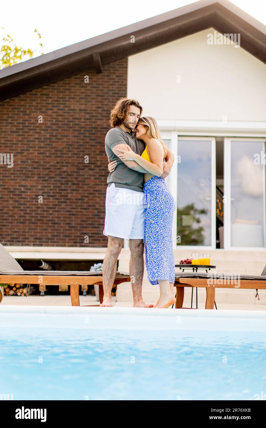 Handsome young couple relaxing by the swimming pool in the house backyard Stock Photo - Alamy