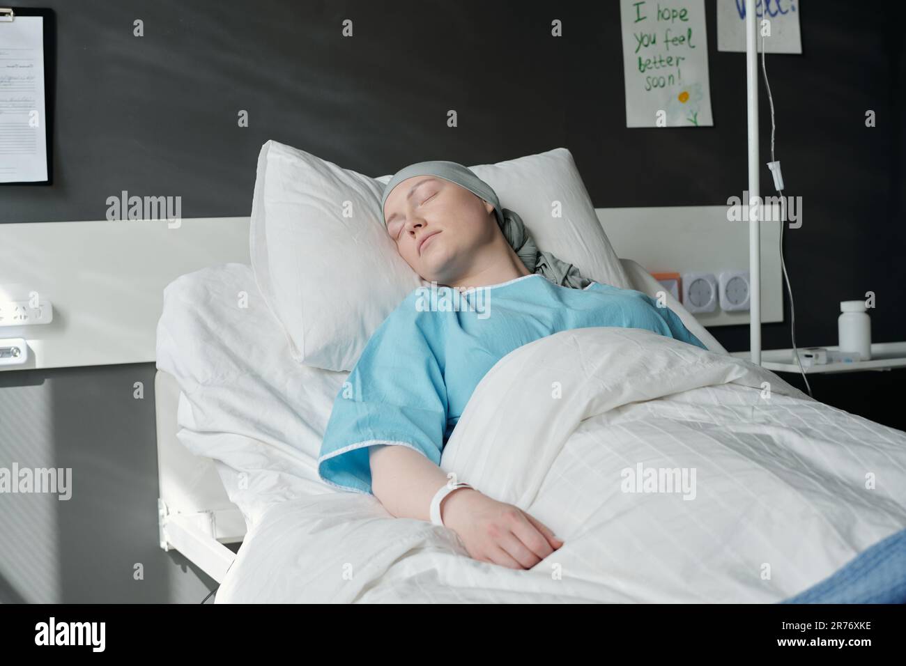 Young tired female patient with oncological disease sleeping under ...