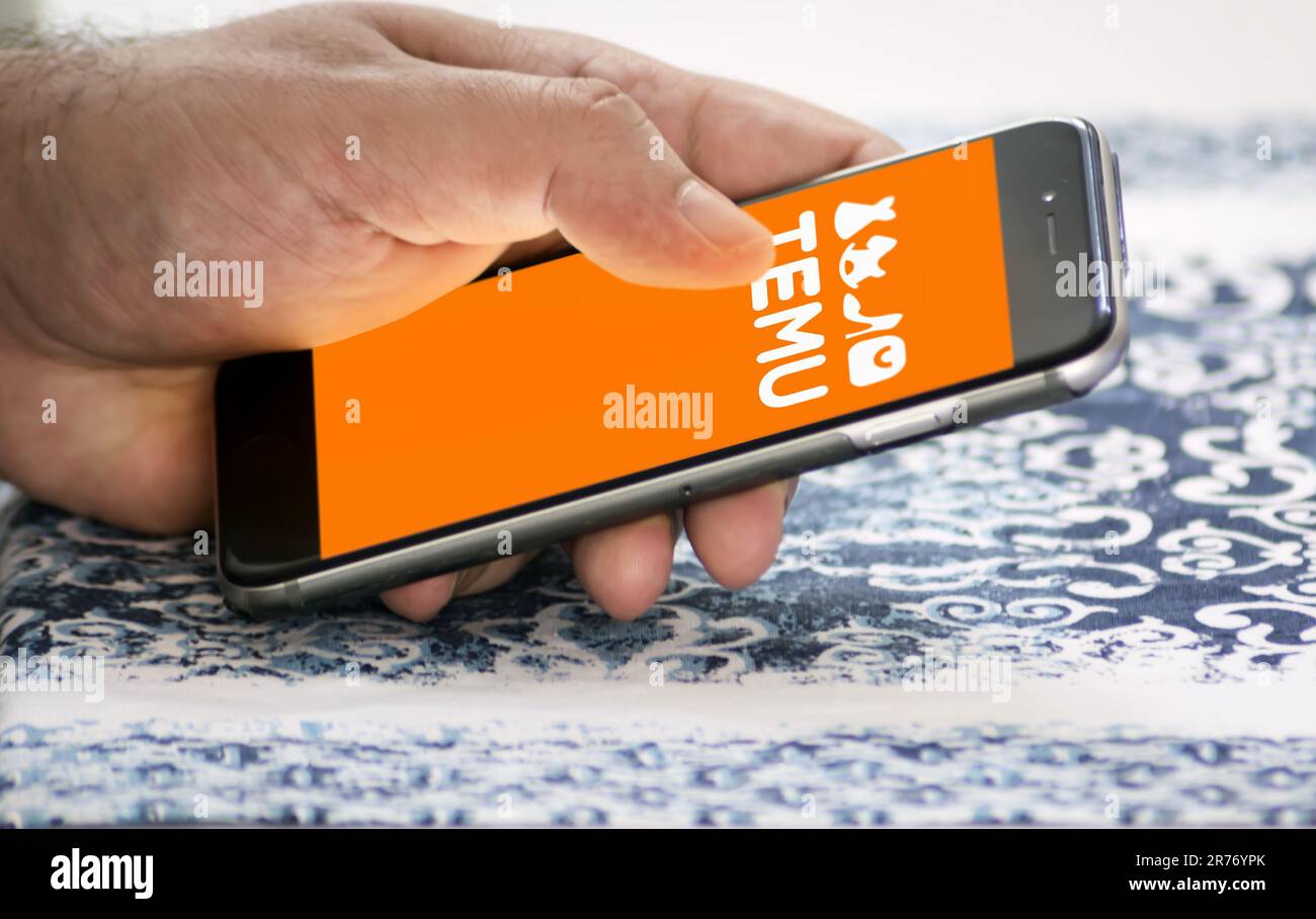 Boston, US, March 2023: Male hand holding a phone with Temu logo ...