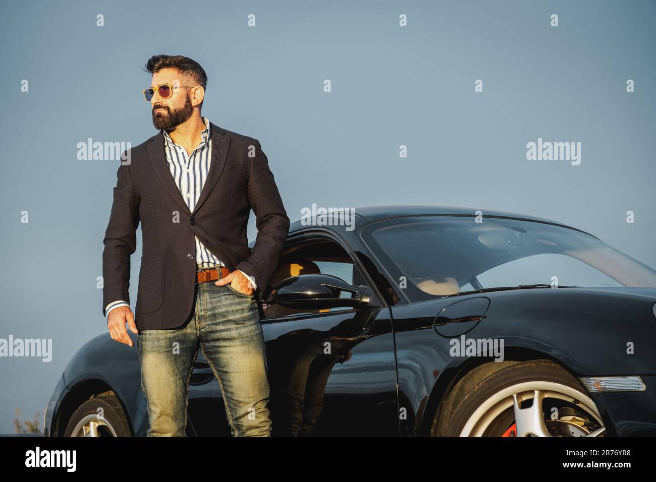 A handsome elegant male next to his sports car Stock Photo - Alamy