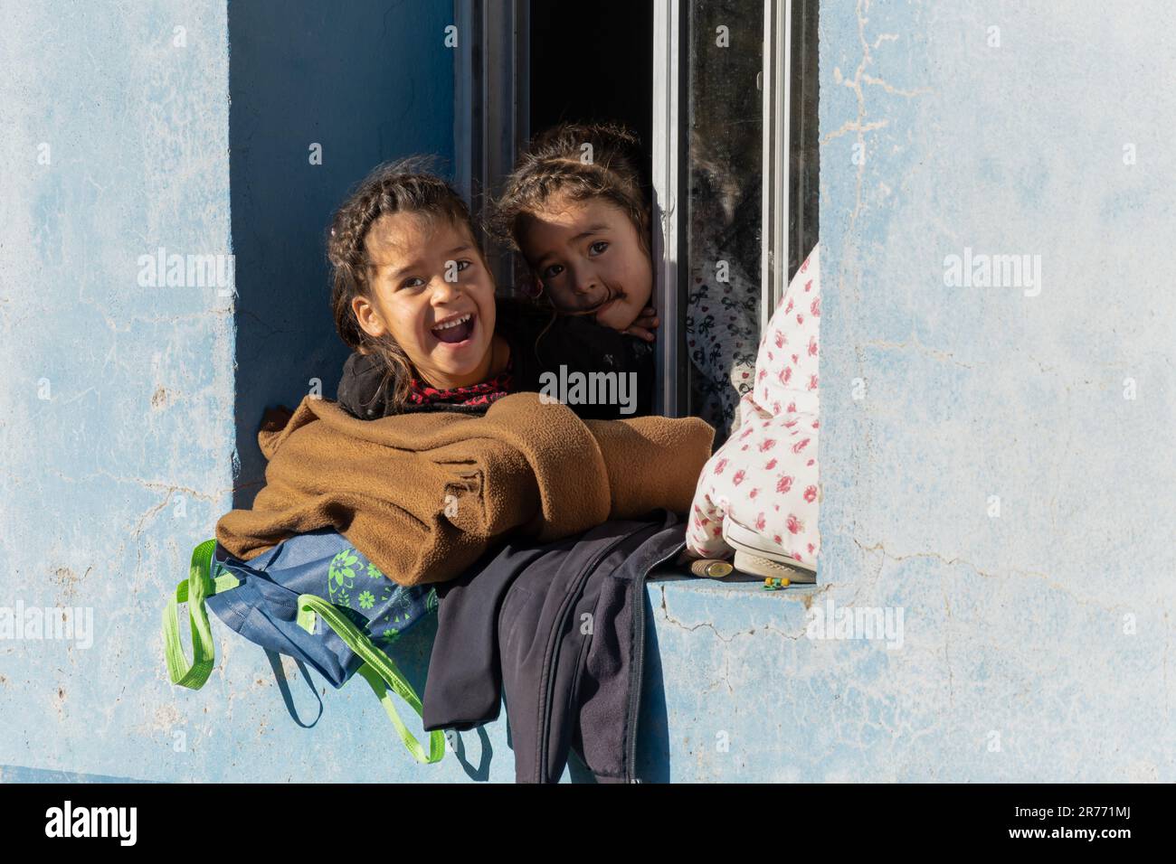 Two children gazing out of an open window from a building Stock Photo ...
