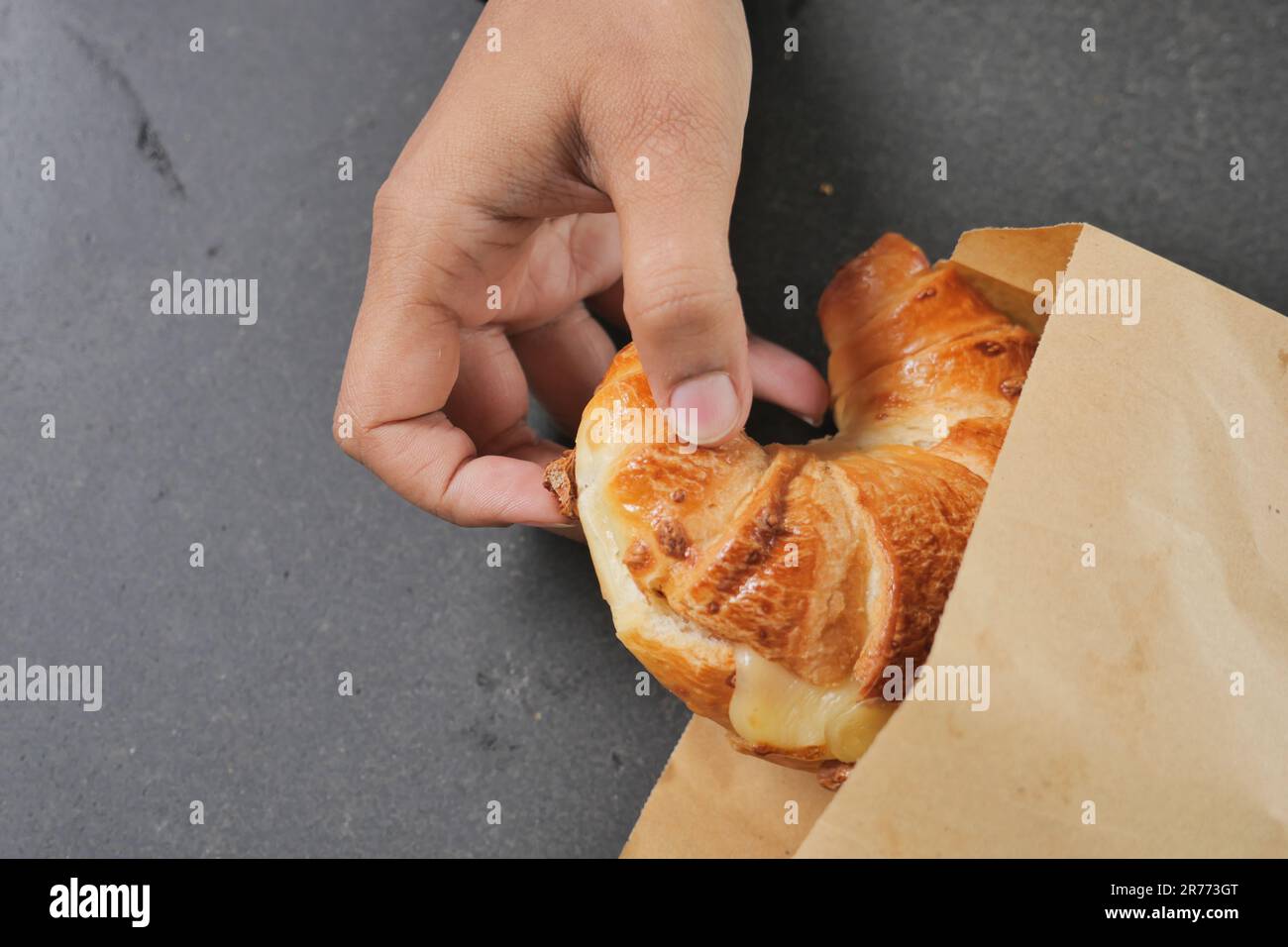 fresh baked croissant in paper packet on table Stock Photo - Alamy