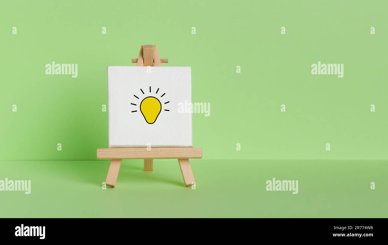 A small canvas painting of an illuminated light bulb, with a gold ...