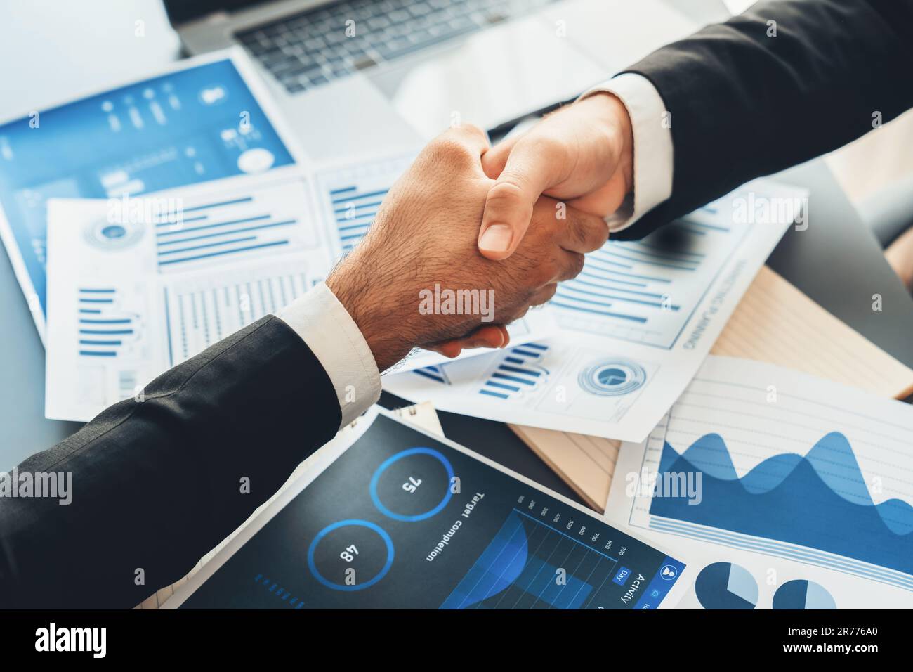 Closeup professional businessman shaking hands over desk in modern ...
