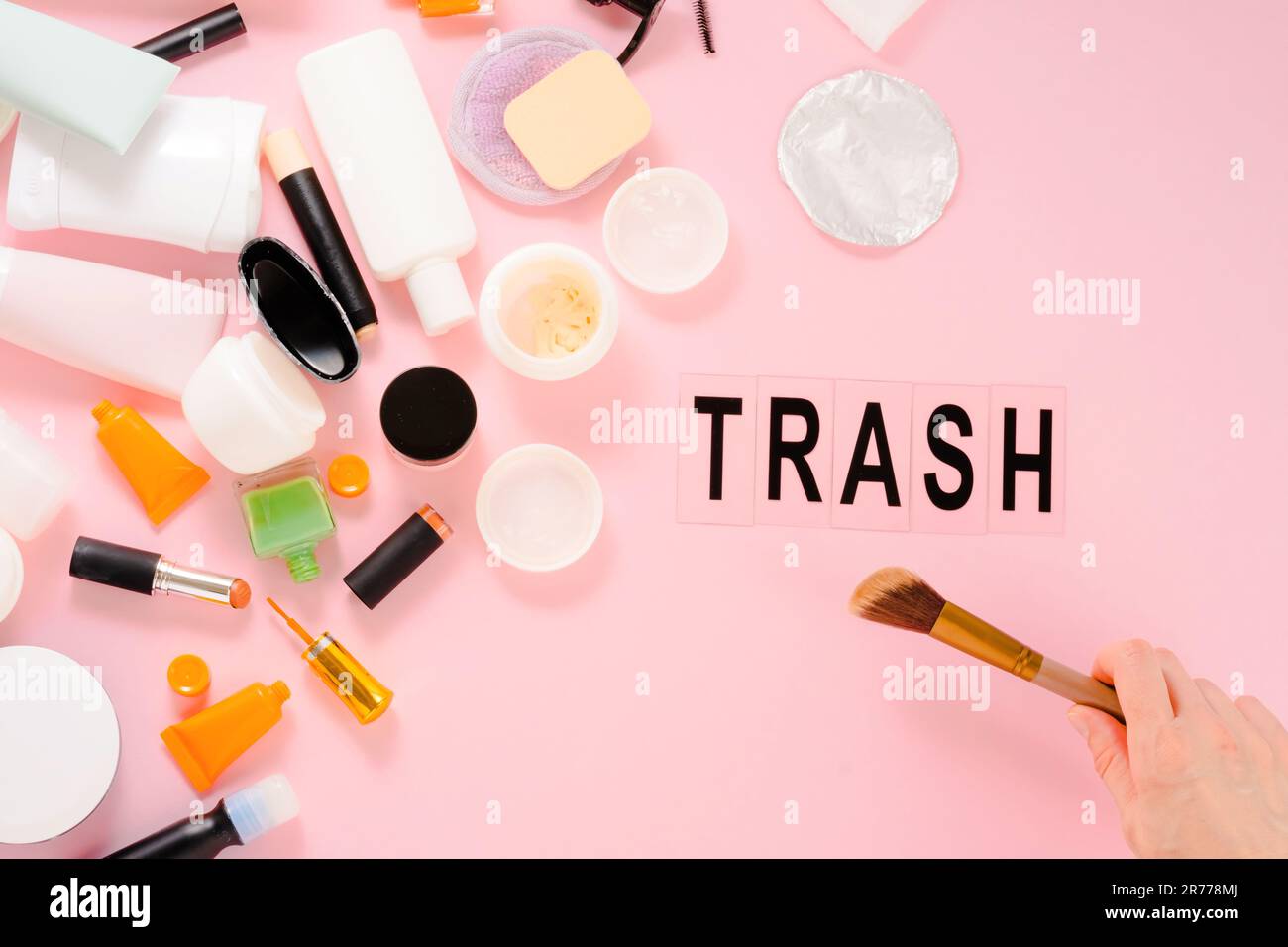 A female hand holding brushes and pointing to the word trash. Beauty ...