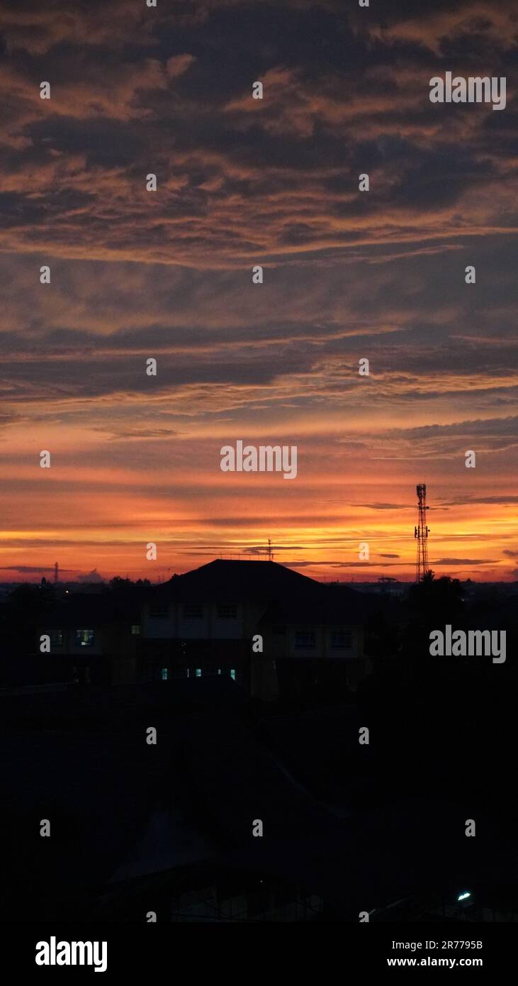 Sunset golden hour with silhouettes of buildings and towers Stock Photo ...