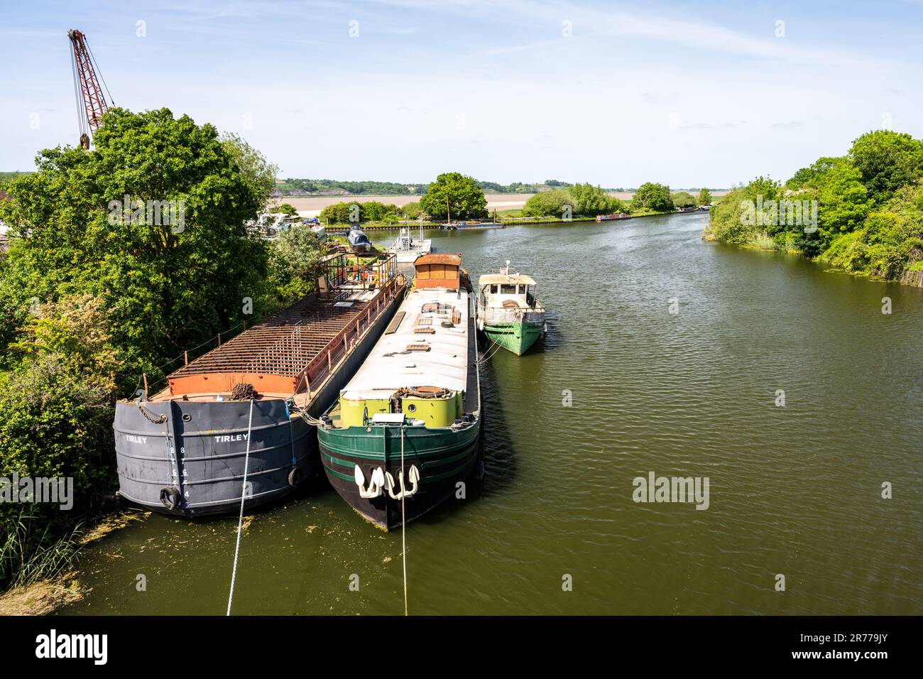 Canal boats are moored at an overgrown quay at Sharpness Docks on the ...