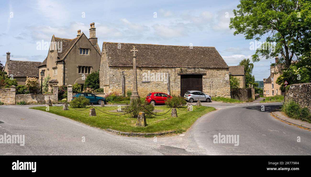 A traditional barn and houses stand beside a small village green in ...
