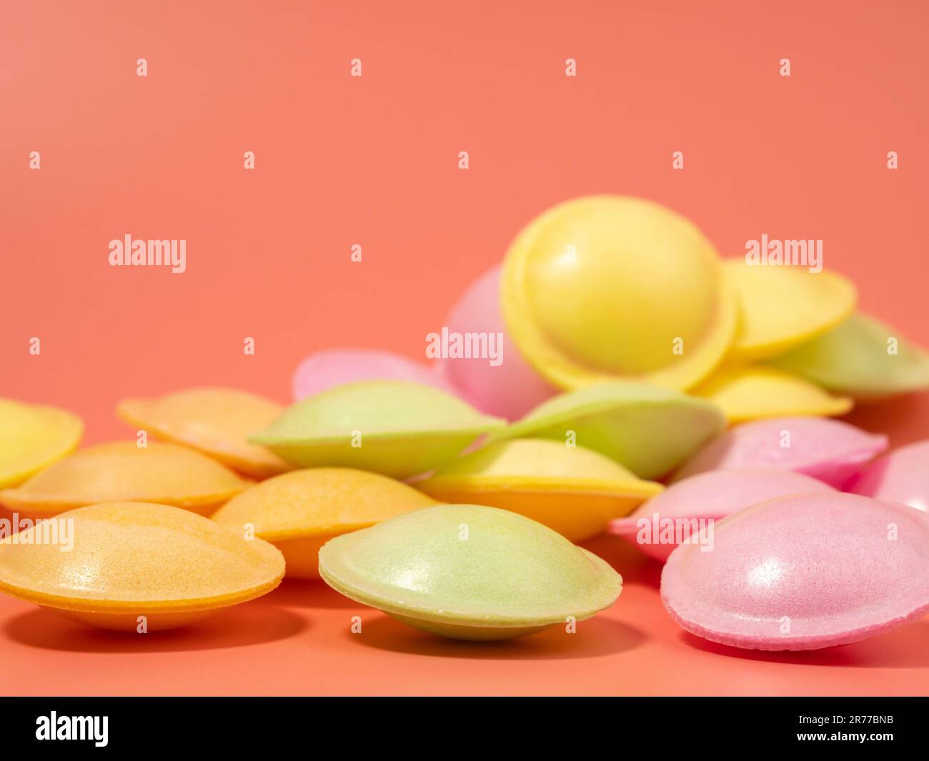 Sweet candies in the shape of a UFO in different colors on a pink ...