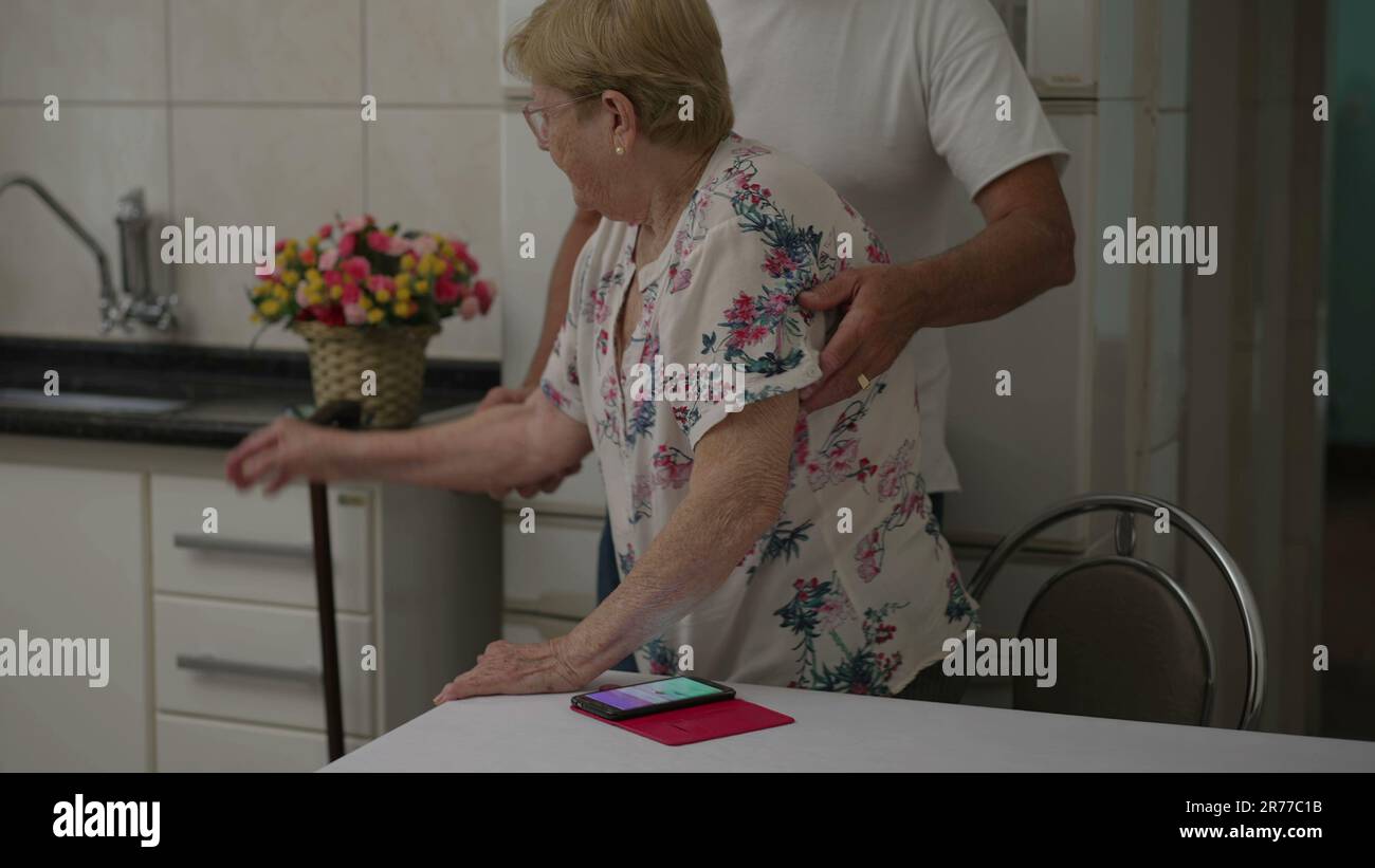 Elderly woman getting up from chair at home, authentic real life ...