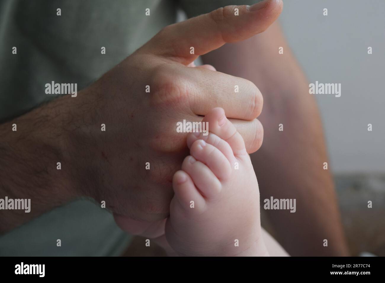 Baby's foot in father's hands Stock Photo - Alamy
