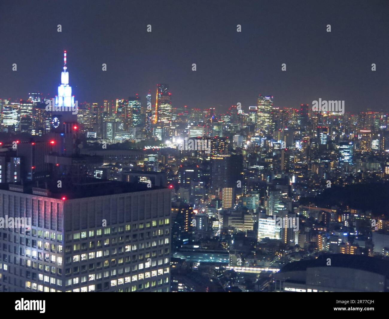 Tall skyscrapers illuminated at night; the Tokyo skyline viewed from ...