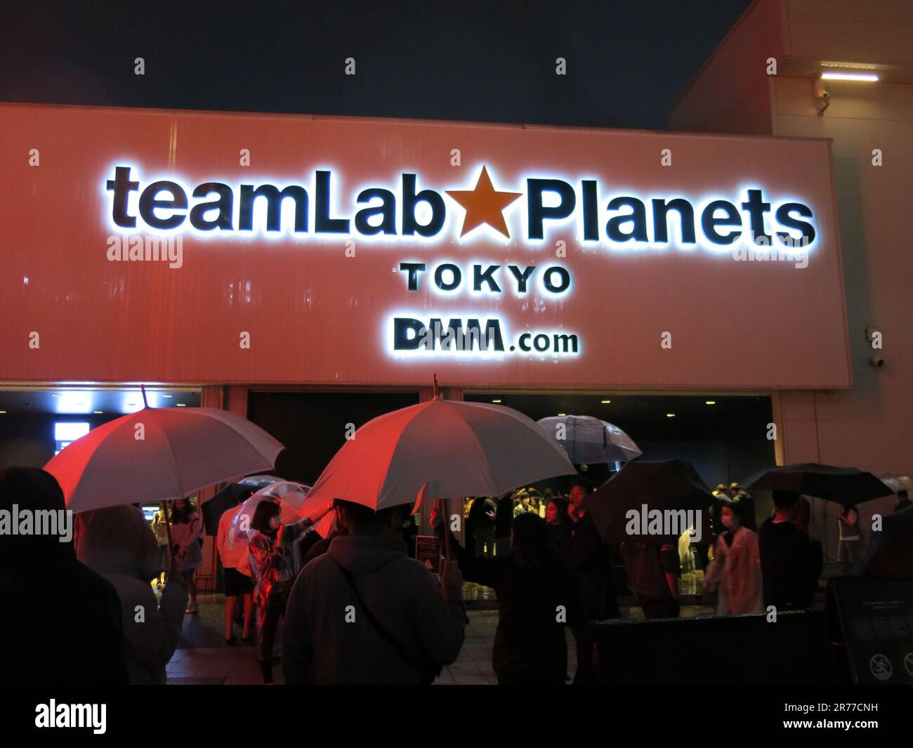 It may be pouring with rain, but customers queue under their umbrellas ...