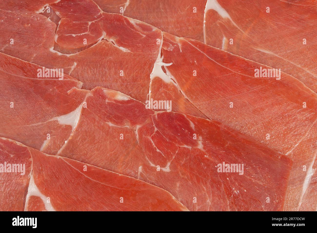 Red ham prosciutto sliced as a background Stock Photo - Alamy
