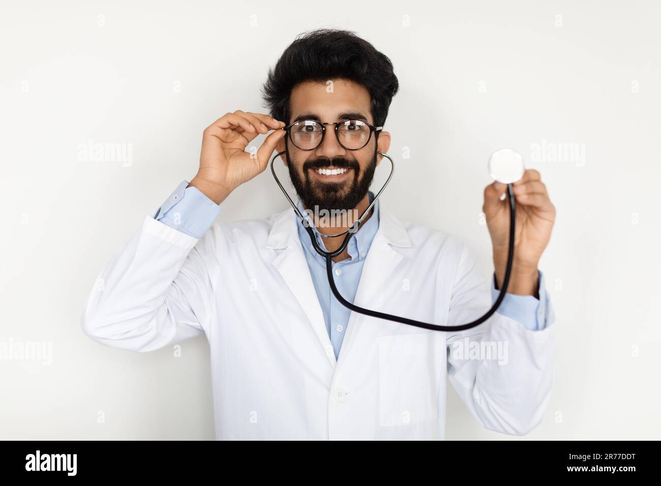Cheerful young arab doctor using stethoscope, white background Stock ...